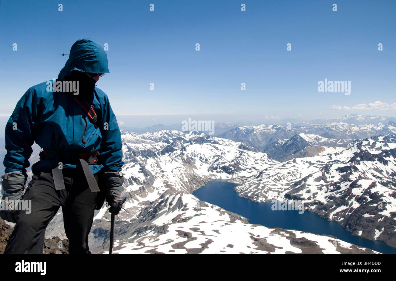 A climber stands at the summit of a peak in the Andes Mountains Stock ...