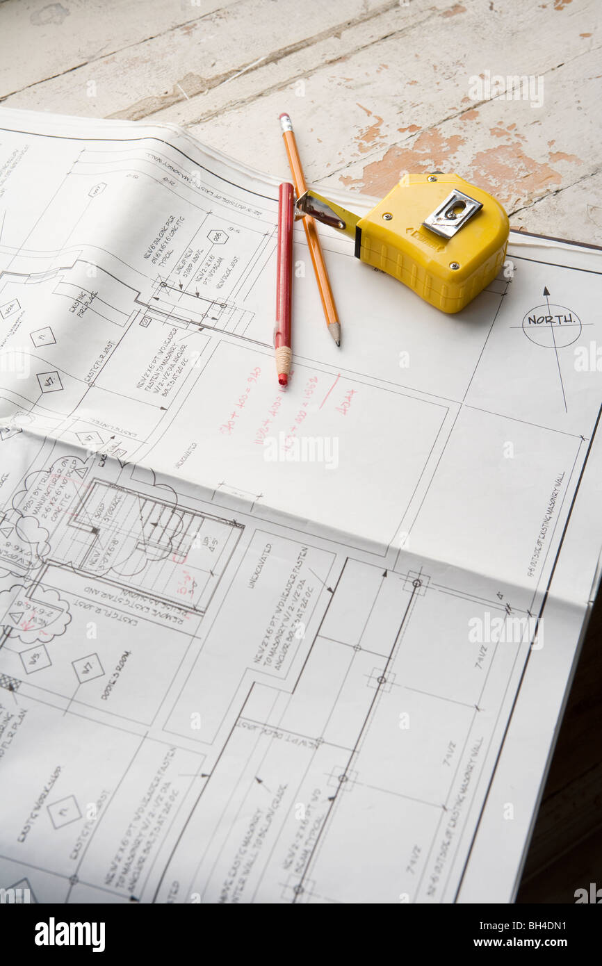 Pencils and measuring tape on building plans Stock Photo - Alamy