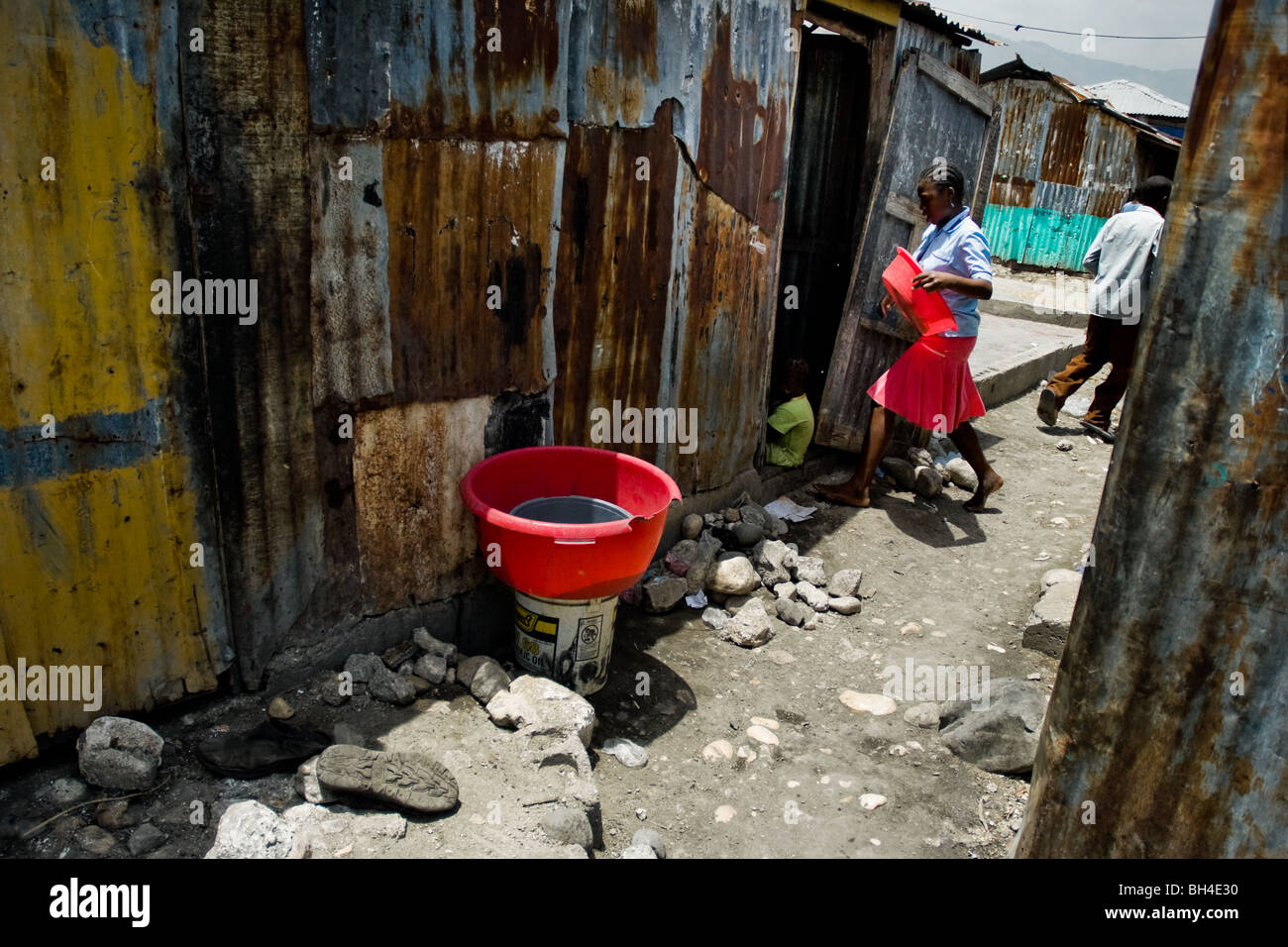 A Haitian woman entering a shack in the slum of Cité Soleil Stock Photo ...