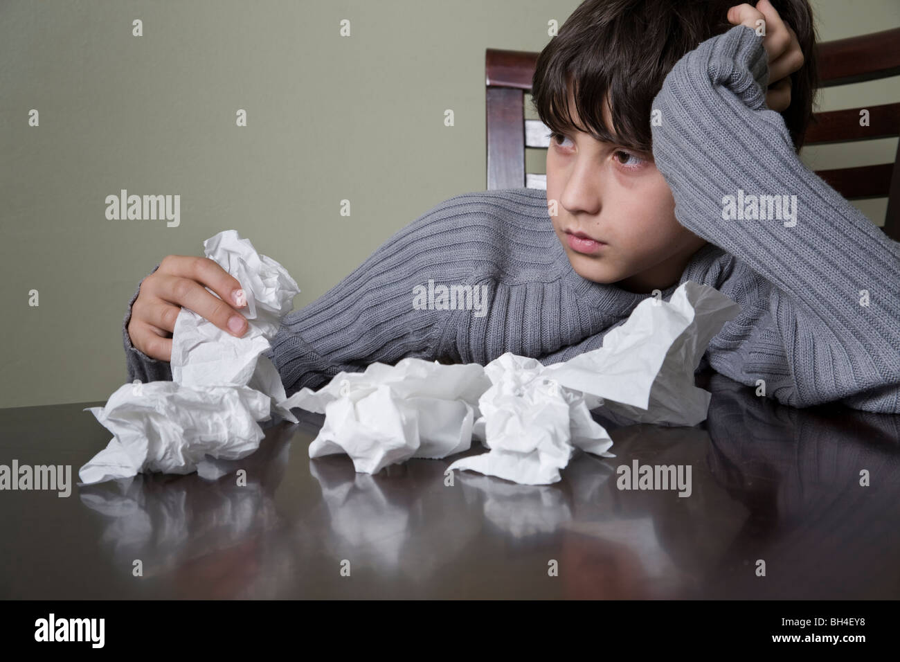 Young boy with a cold using tissues Stock Photo - Alamy