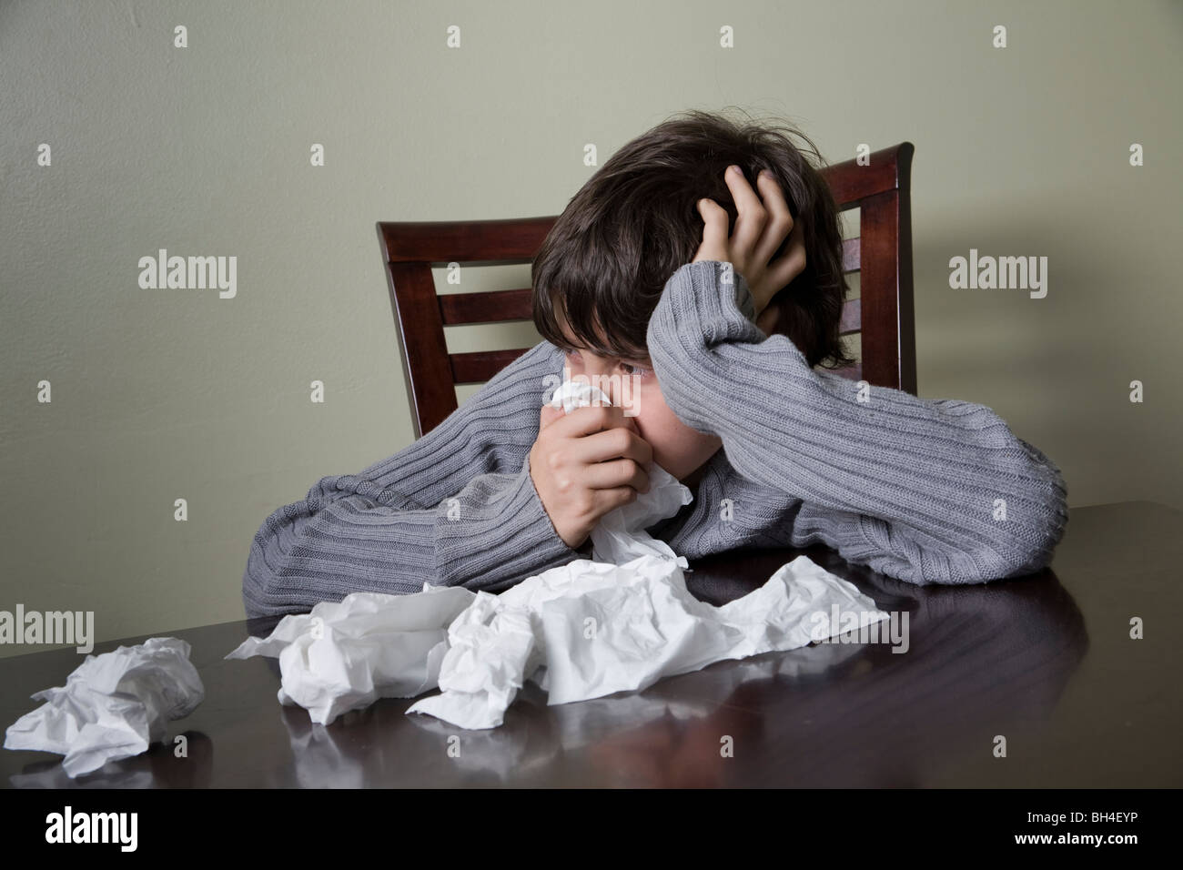 Young boy with a cold using tissues Stock Photo - Alamy