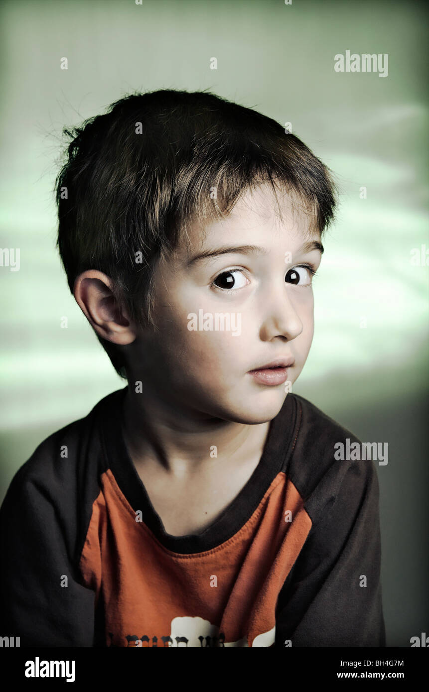 Young boy looking surprised in front of green backround, Otterburn Park ...