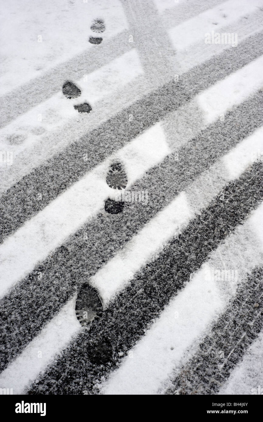 Tyre Tracks and Footprints on a snow covered road Stock Photo - Alamy