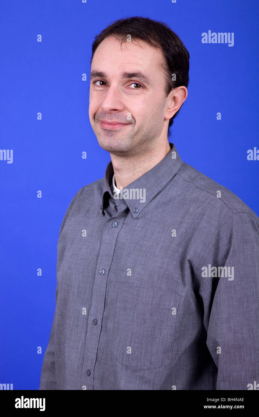 an young man portrait over a blue background Stock Photo - Alamy