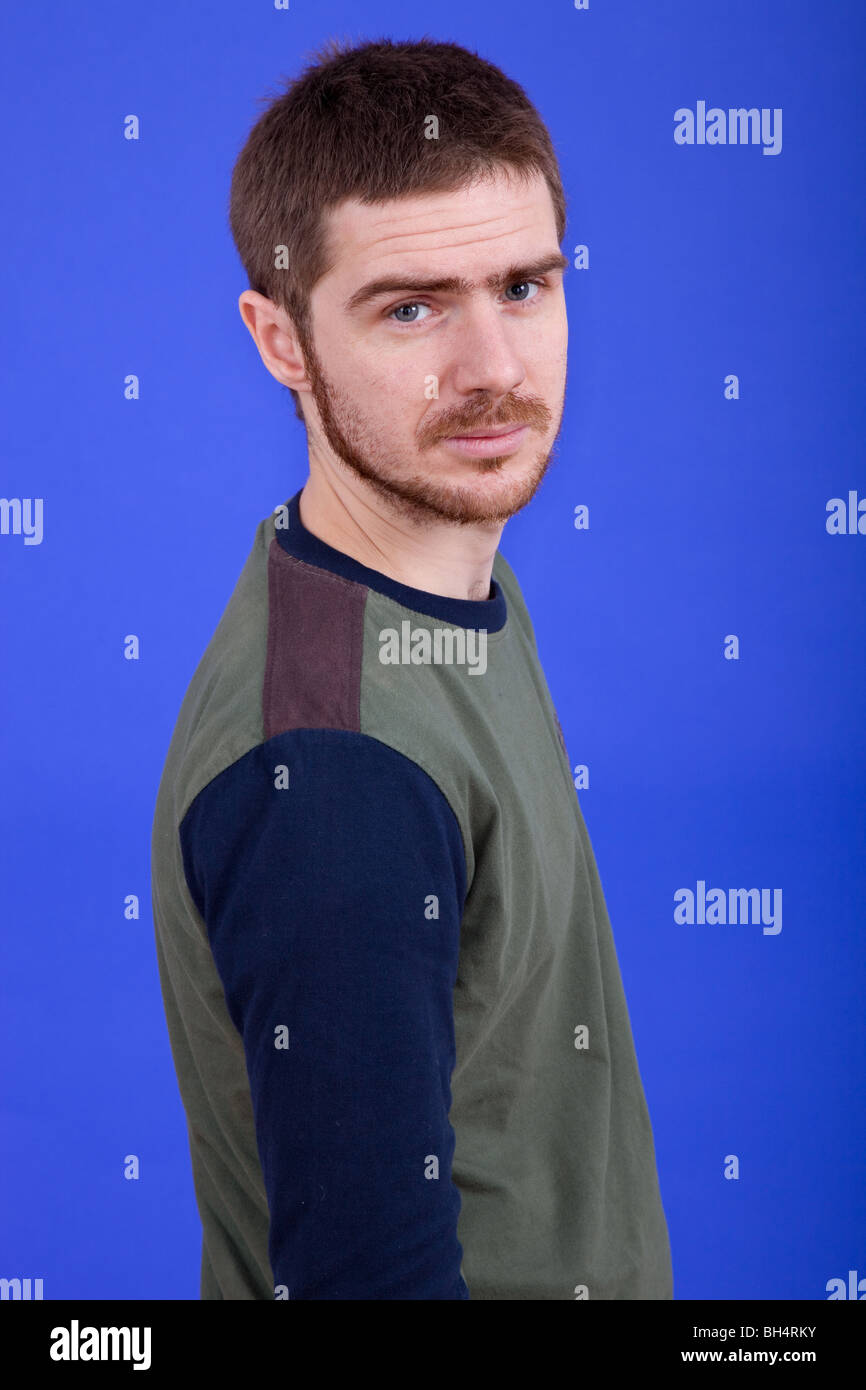 an young man portrait over a blue background Stock Photo - Alamy