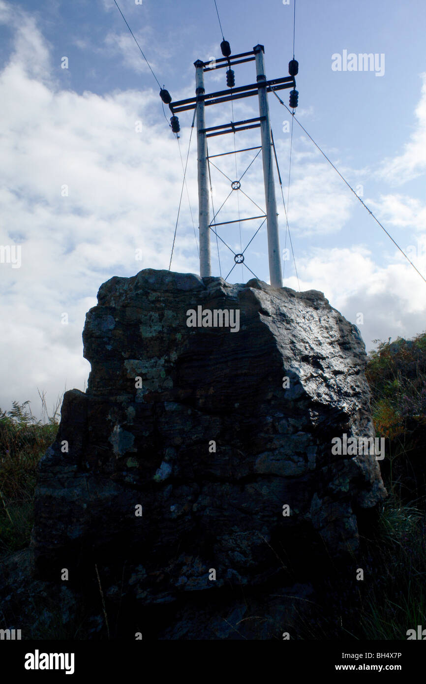 Electricity pylon appearing to grow from the rocks Stock Photo - Alamy