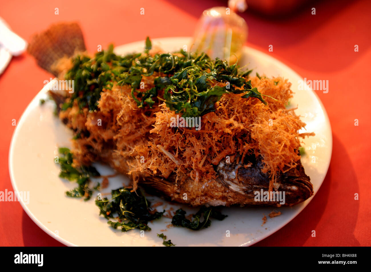 Deep fried fish with lemongrass and basil leaves on top, Bangkok ...