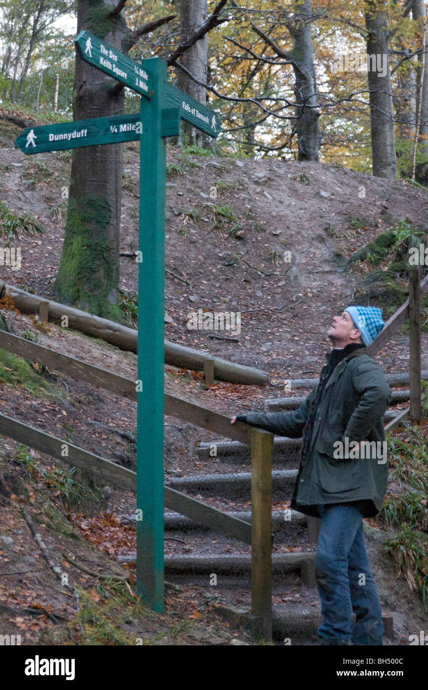 Hiker reading green signpost at Falls of Tarnash Stock Photo - Alamy