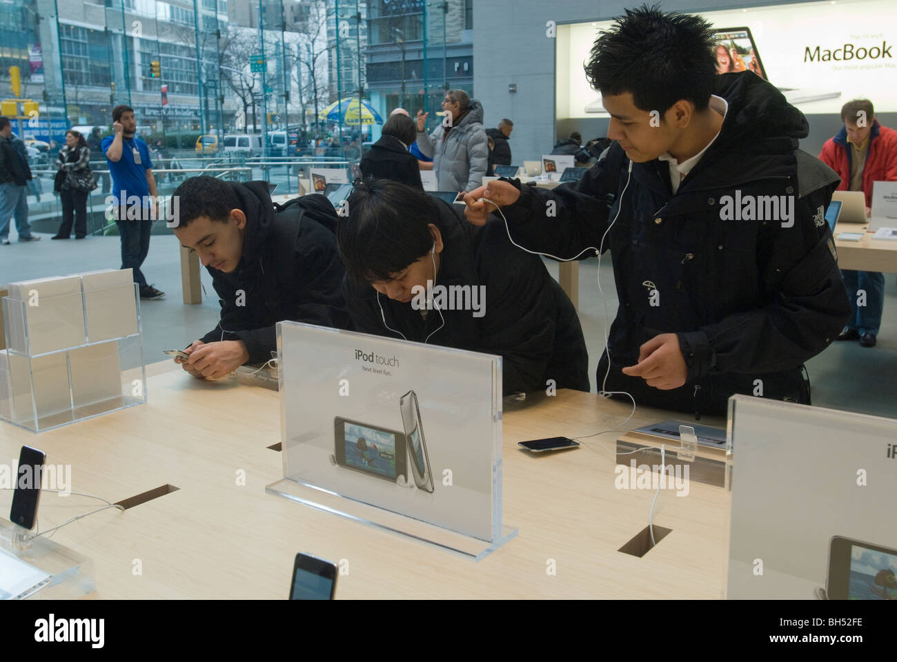 Teens listen to music on iPod Touches in the Apple store in the Upper ...