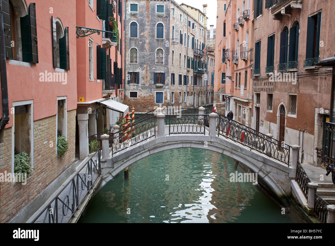 A typical canal scene in Venice, Italy, with a footbridge in the ...