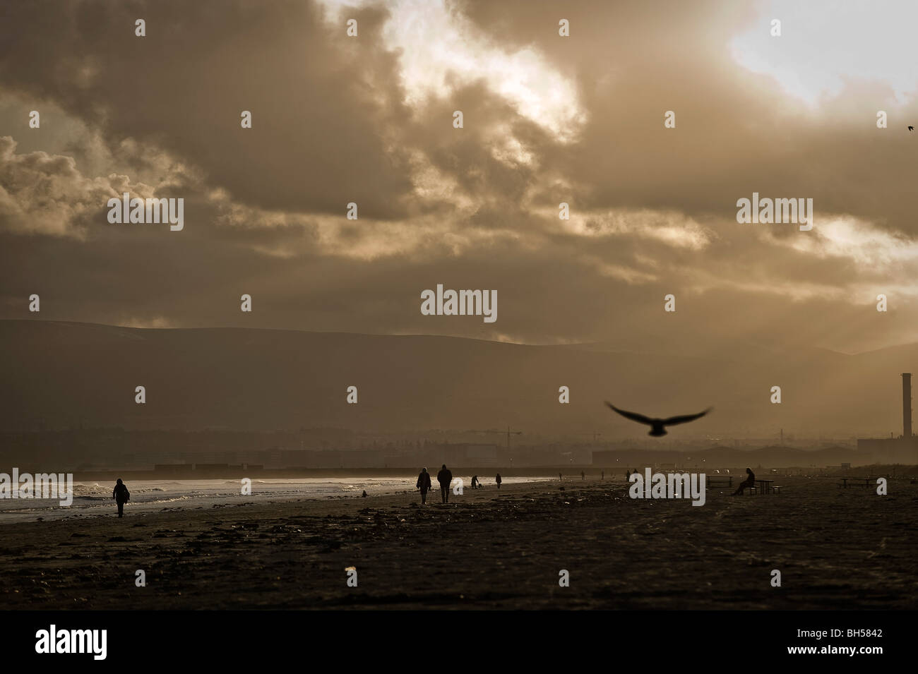 Dollymount strand in Dublin Ireland. People walking on the beach and a ...