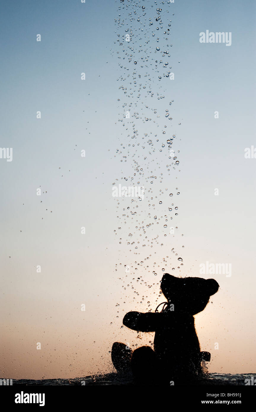 Teddy bear catching water drops silhouette Stock Photo - Alamy