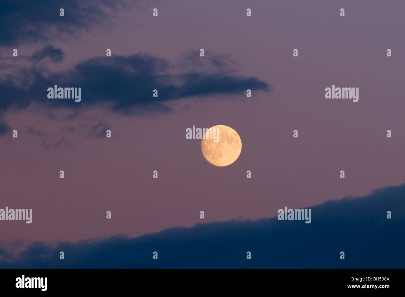 Moon and colorful clouds at sunset Stock Photo - Alamy
