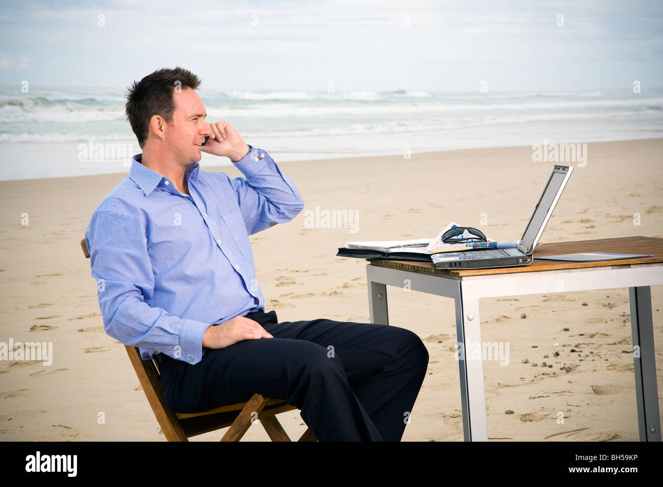 Business man with office on the beach Stock Photo - Alamy