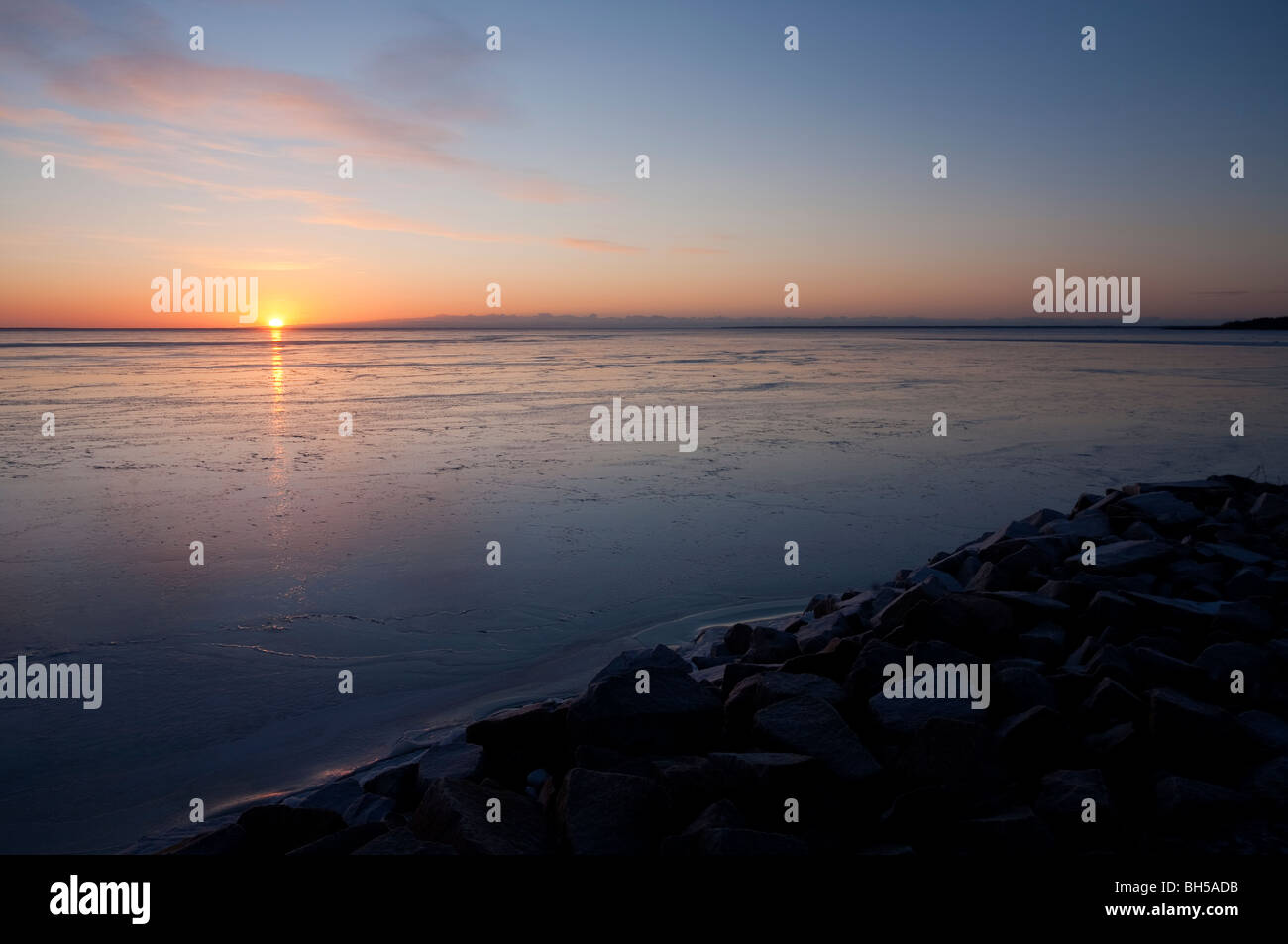 Last rays of sun reflecting from new pristine sea ice at sunset ...