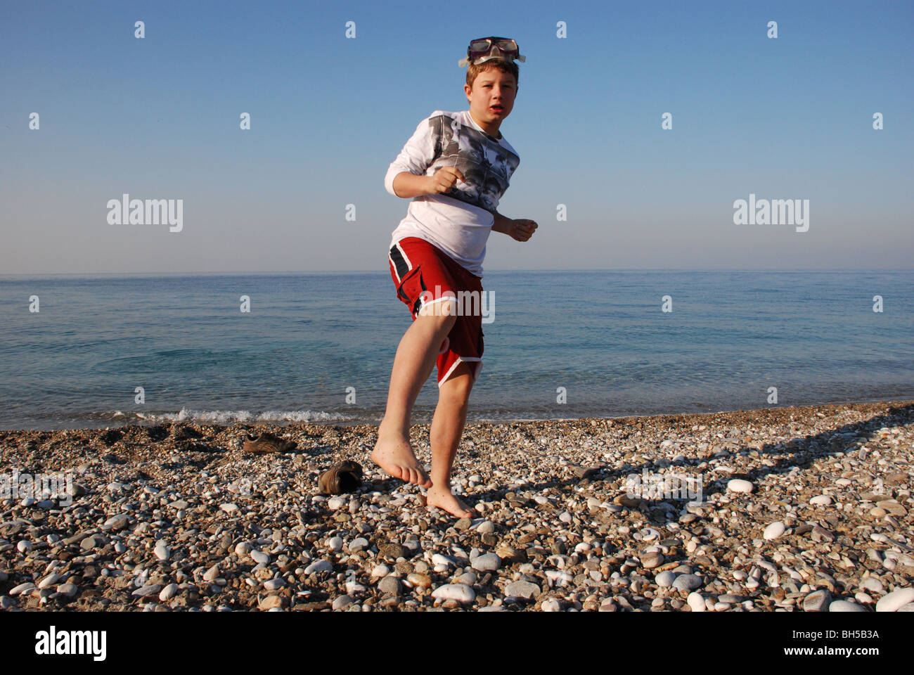 boy fooling around on a beach Stock Photo - Alamy