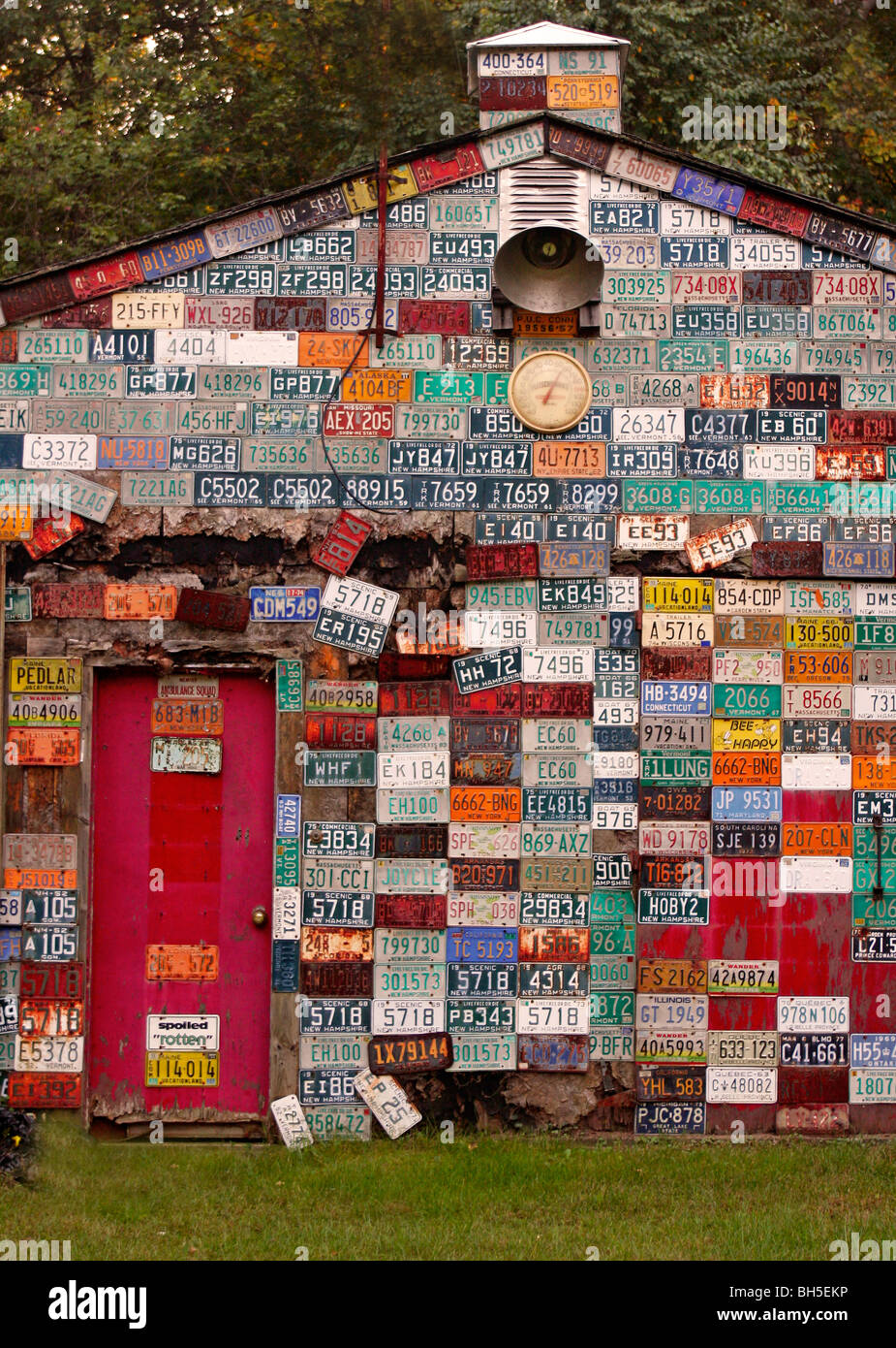 wall of metal car license plates on garage with red door Stock Photo ...