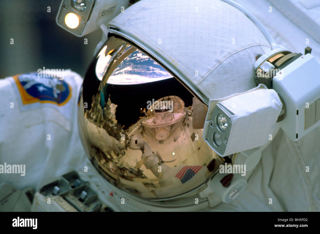 Shuttle Discovery and Earth reflected in helmet of NASA astronaut Stock ...