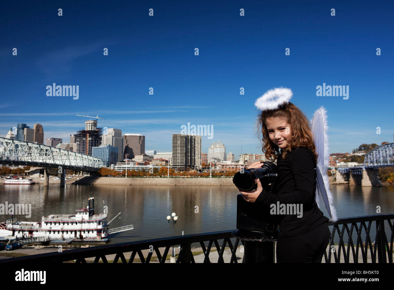LITTLE GIRL IN COSTUME OF AN ANGEL FACING CINCINNATI DOWNTOWN SKYLINE ...
