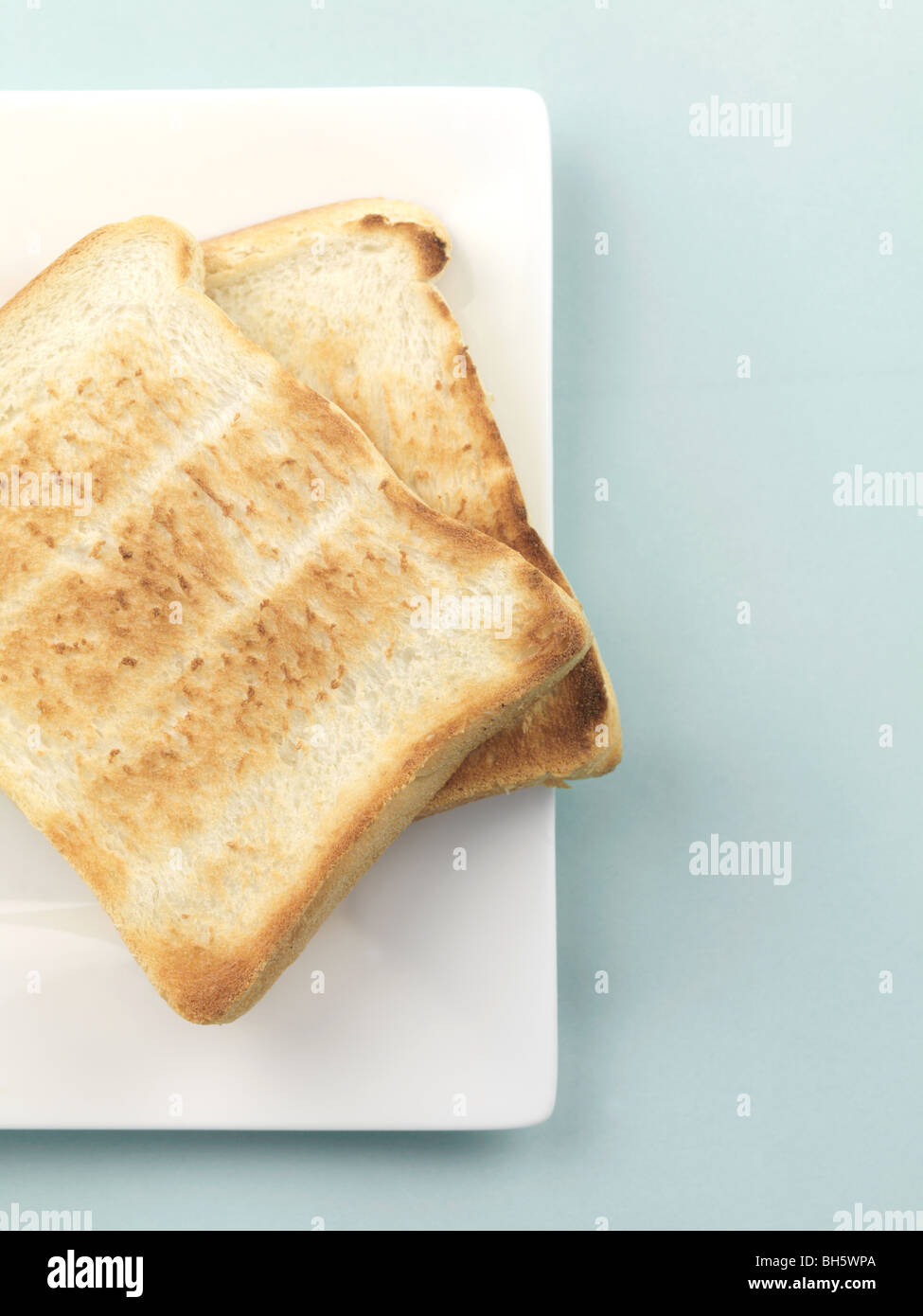 Plain white toast isolated against a pale blue background Stock Photo ...