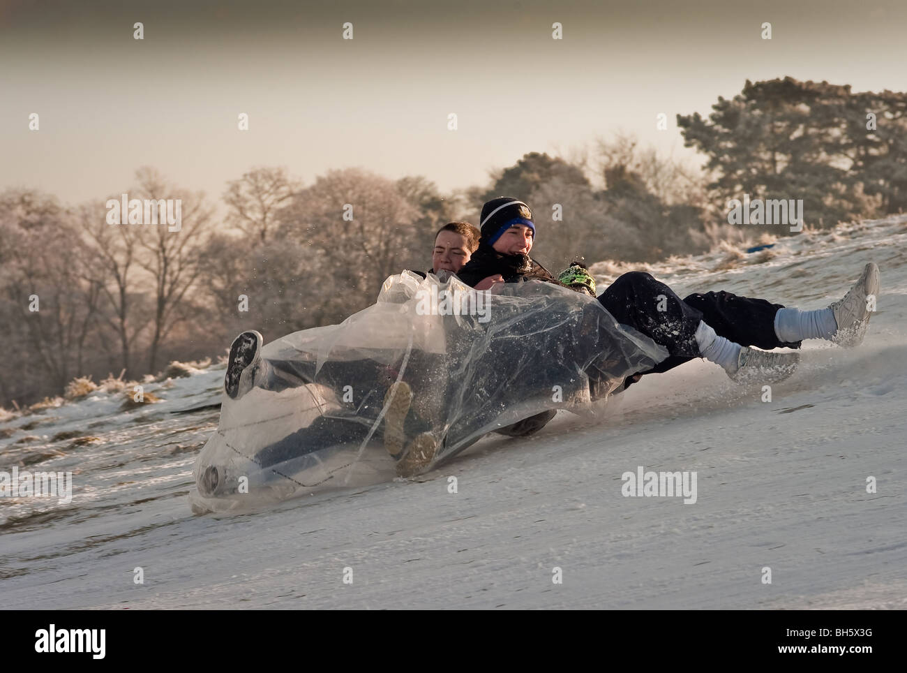 Three boys sliding down a hill in Phoenix Park Stock Photo - Alamy