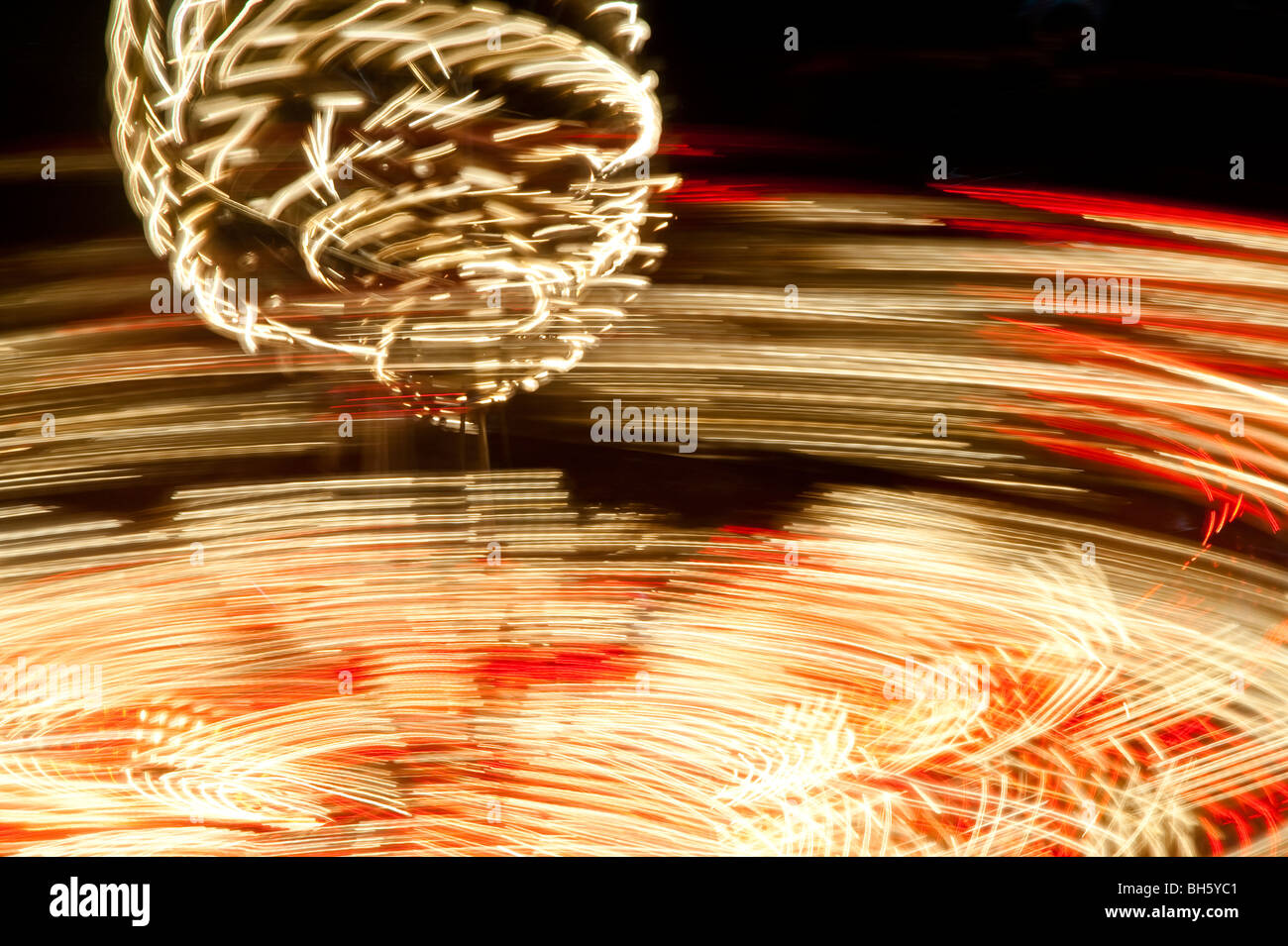 Swirling lights of carnival rides at night Stock Photo - Alamy