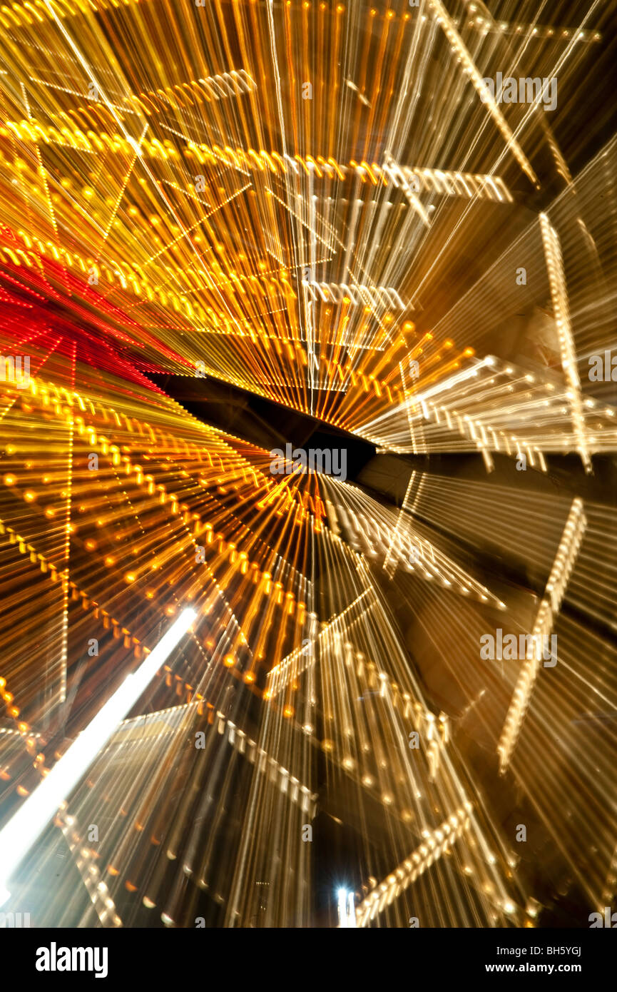 Swirling lights of carnival rides at night Stock Photo - Alamy