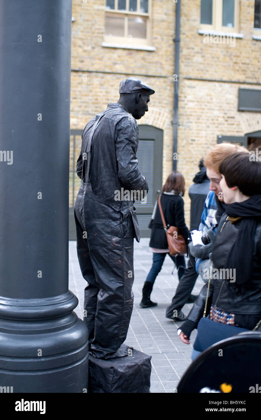 A man poses as a statue in a market in East London Stock Photo - Alamy