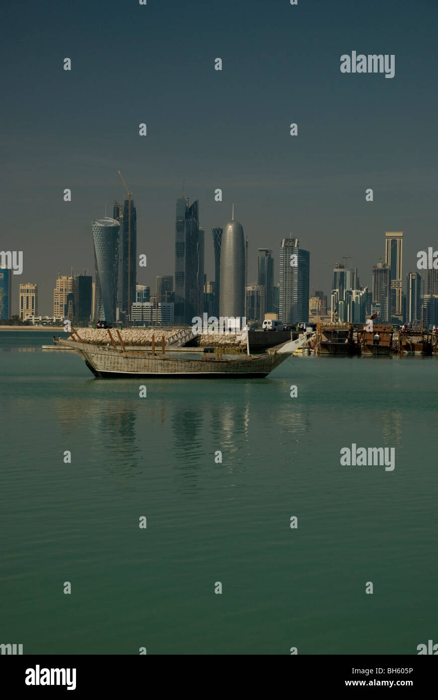 Portrait view of Doha, Qatar skyline with sea in foreground and dhow ...