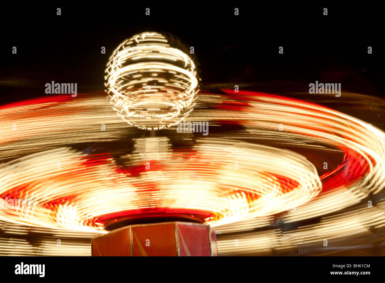 Swirling lights of carnival rides at night Stock Photo - Alamy