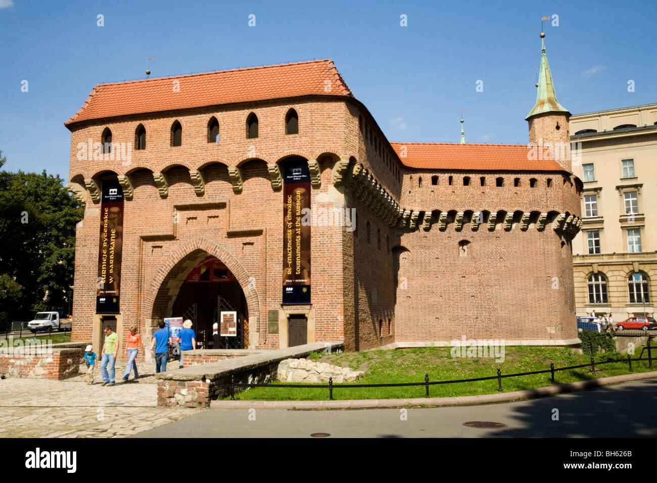 Tourists enter the inner gate of the Barbican of Krakow – which faces ...