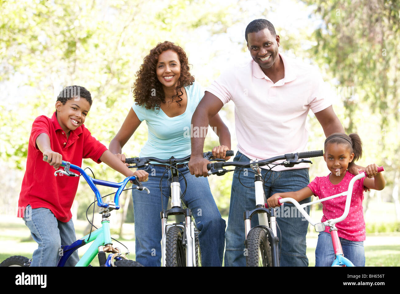 Young Family Riding Bikes In Park Stock Photo - Alamy