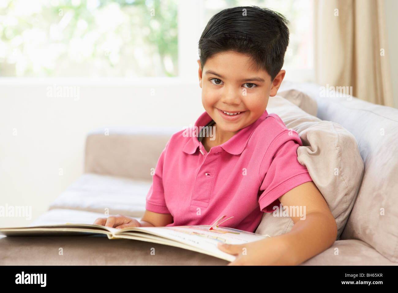 Young Boy Reading Book At Home Stock Photo - Alamy