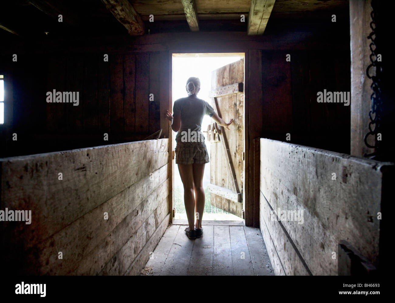 girl looking out barn door Stock Photo - Alamy
