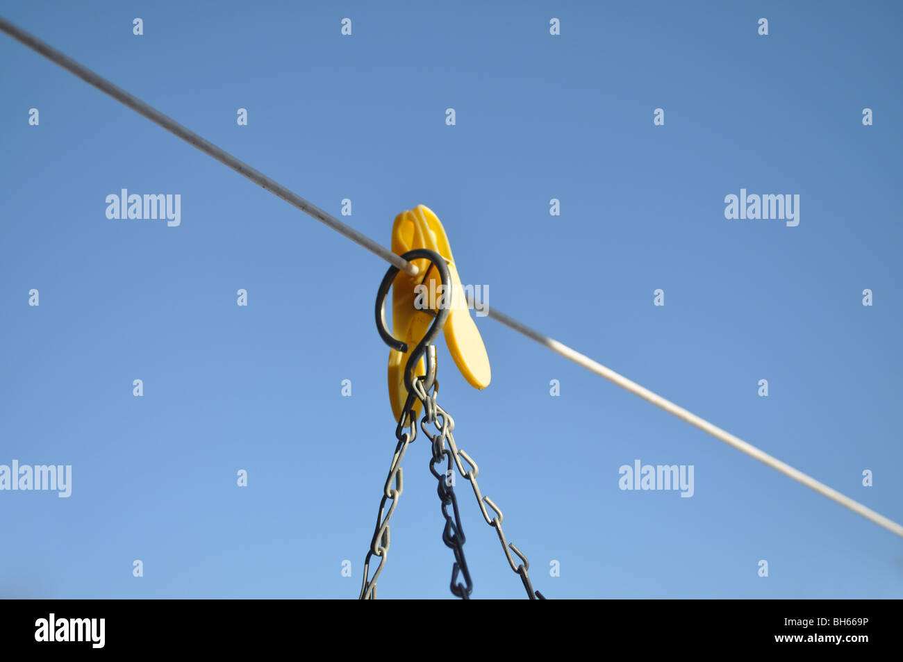 Yellow clothes peg on washing line with hanging basket chain Stock ...