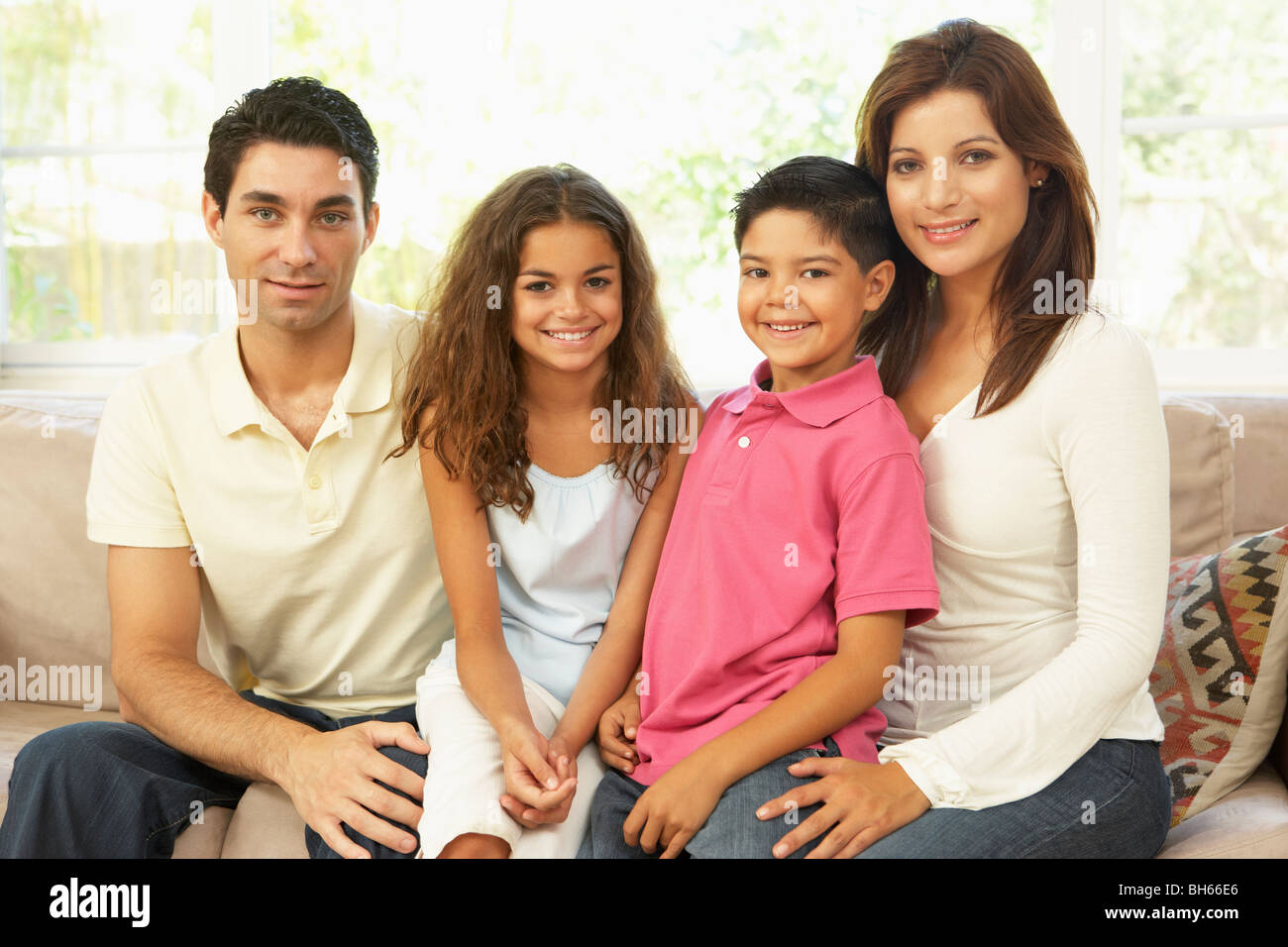 Family Sitting On Sofa At Home Stock Photo - Alamy