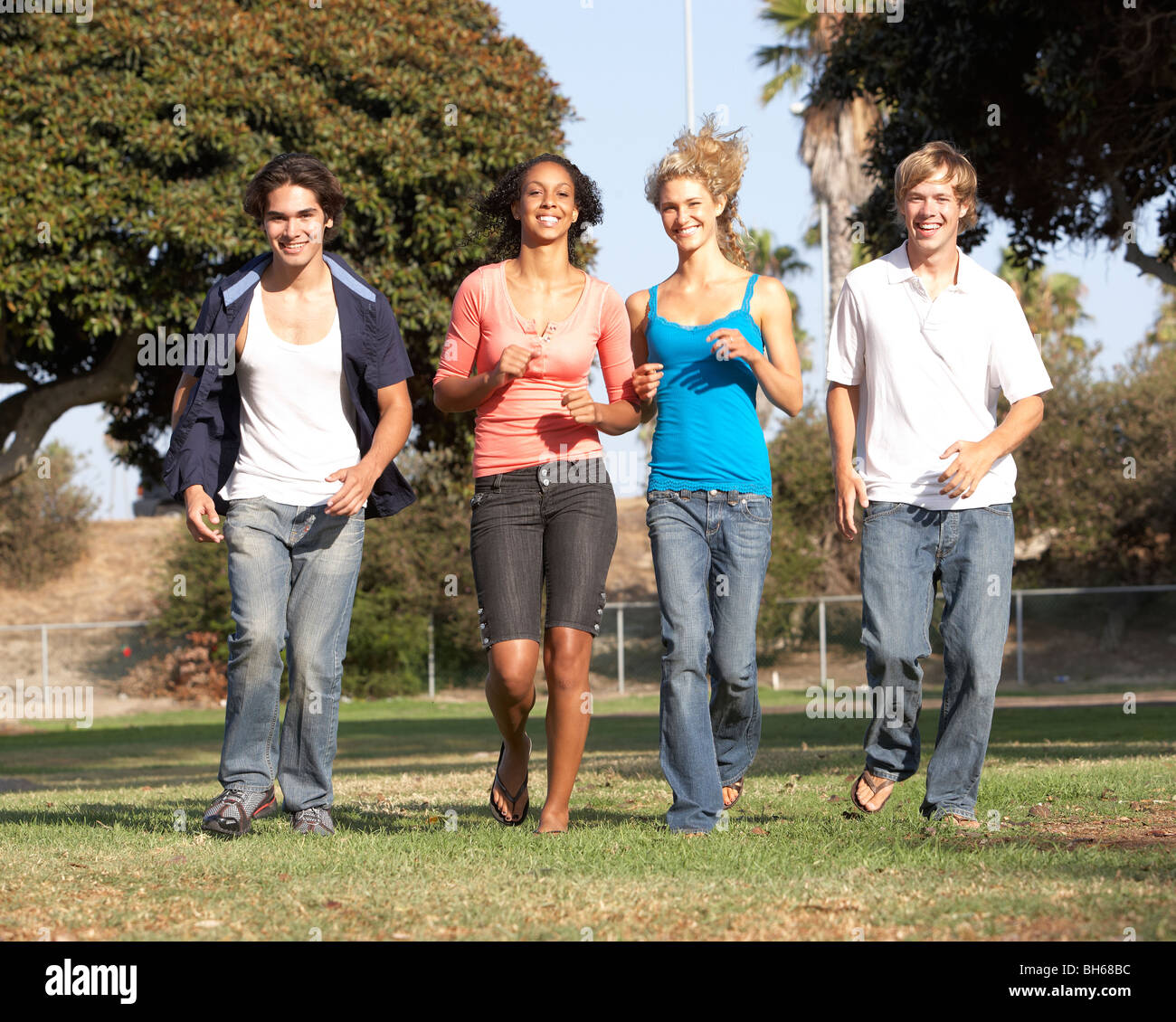 Group Of Teenagers Running In Park Stock Photo - Alamy