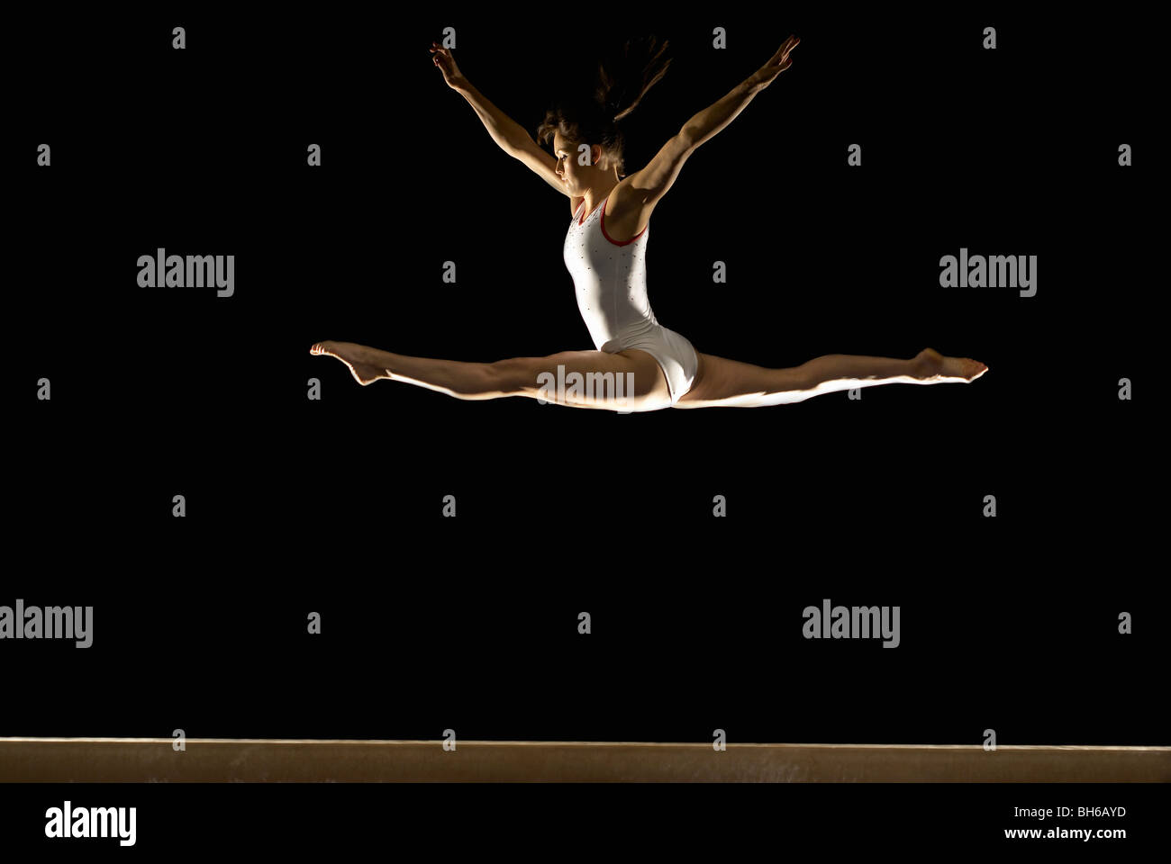 gymnast jumping on beam Stock Photo - Alamy