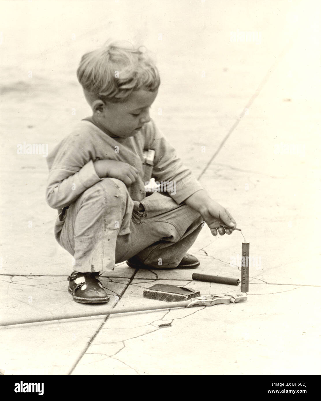 Little Boy Lighting Fireworks on Sidewalk Stock Photo - Alamy