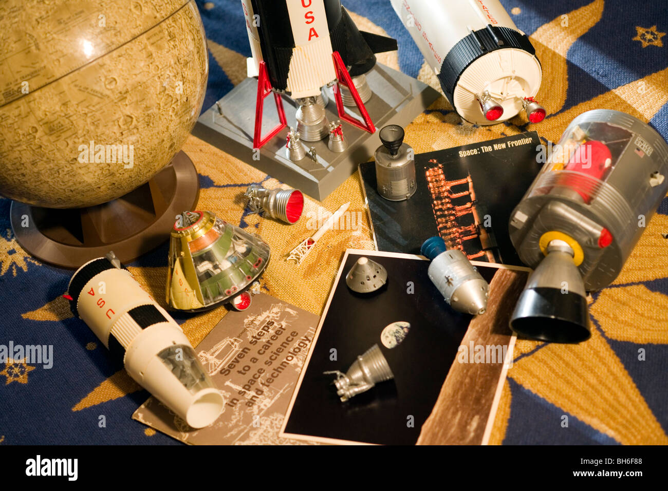 Rocket model, moon globe and space books Stock Photo - Alamy