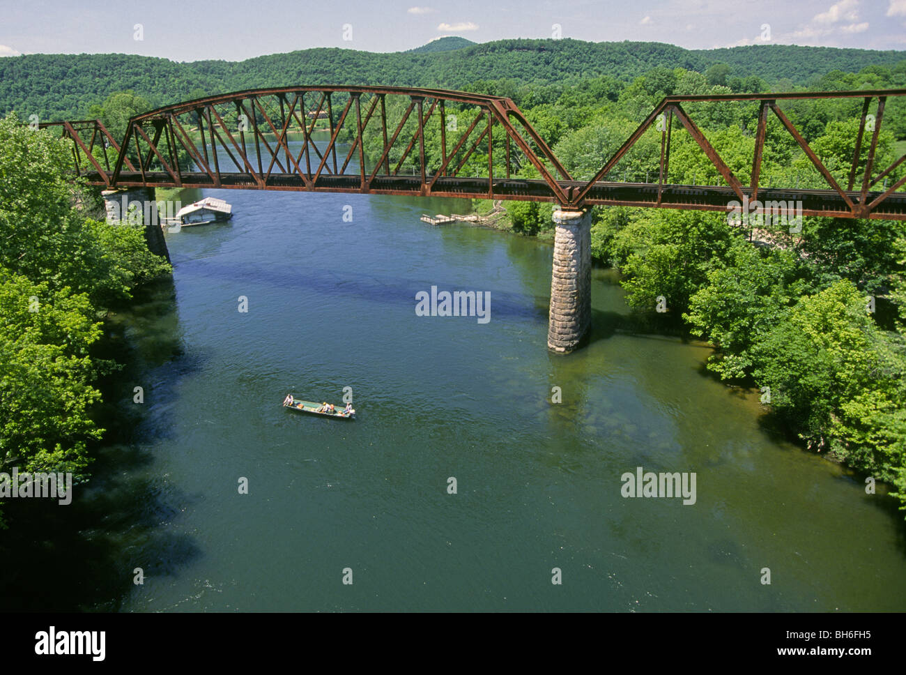 Trout fishermen in a john boat float down the White River in the Ozark ...