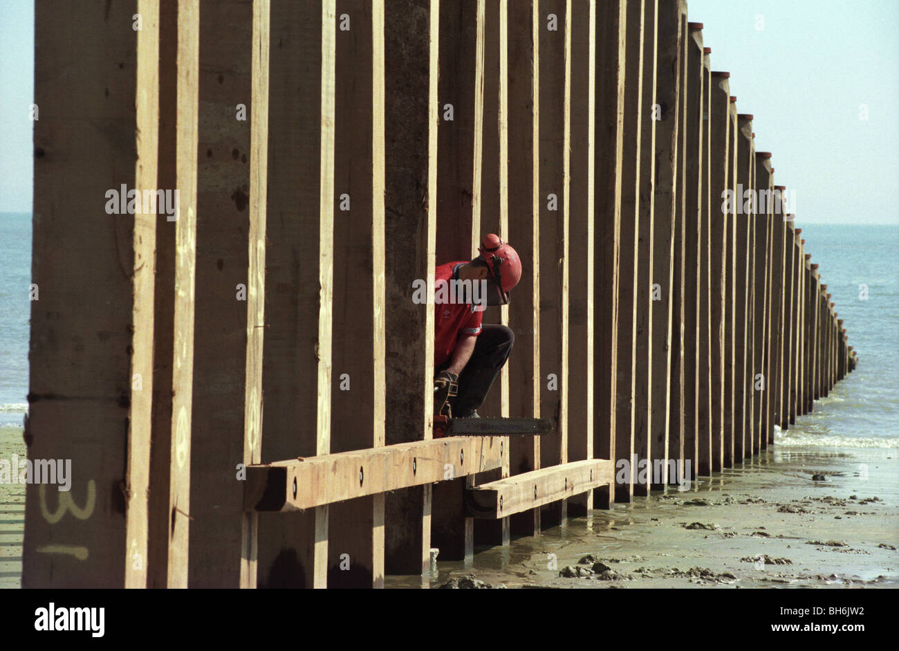 A civil engineer erecting a groyne on the south coast of England as ...