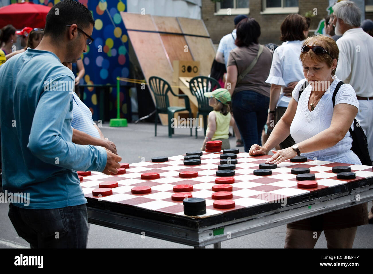 A couple play checkers on a giant board at the Just for laughs Festival ...