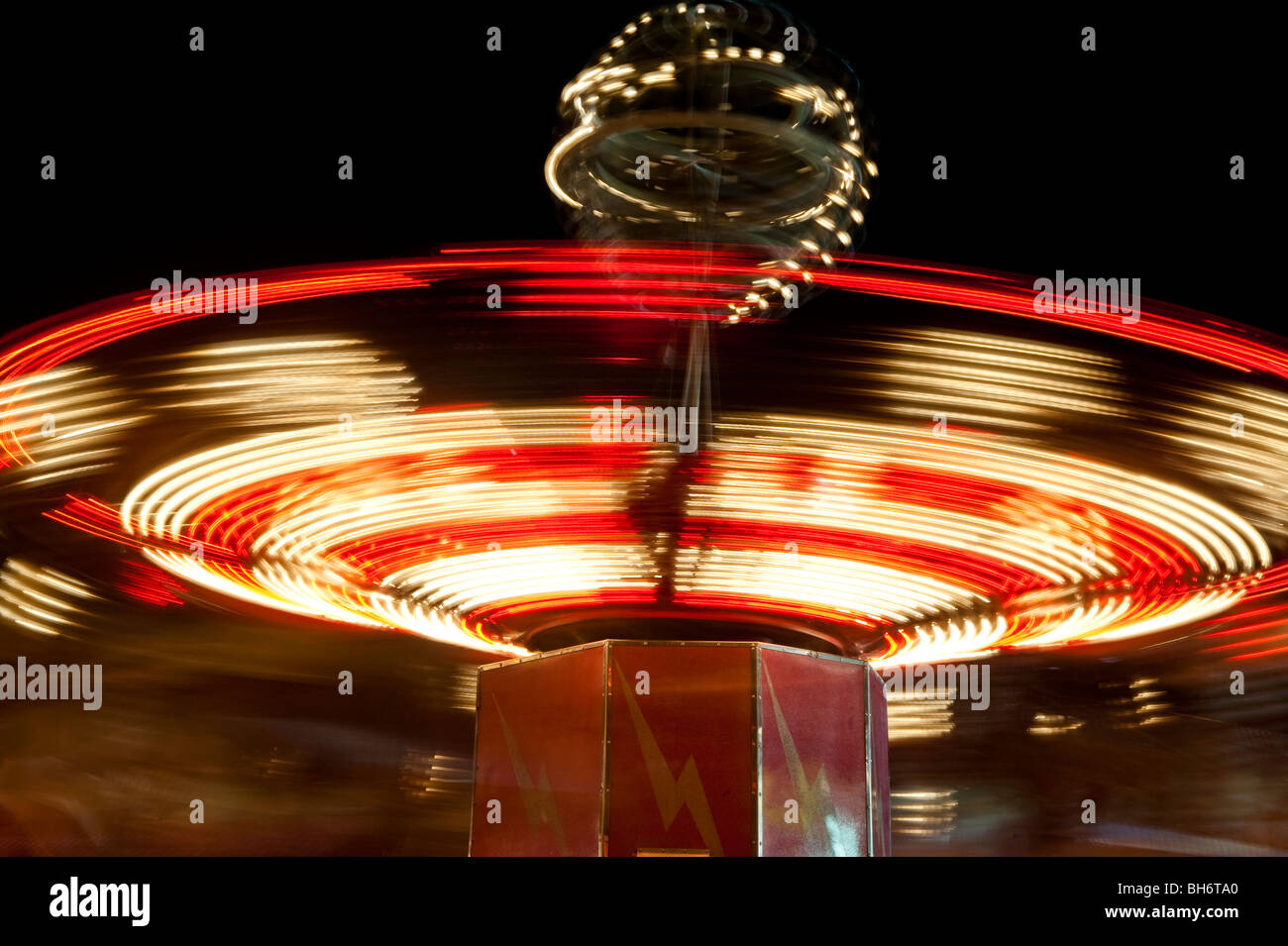 Swirling lights of carnival rides at night Stock Photo - Alamy