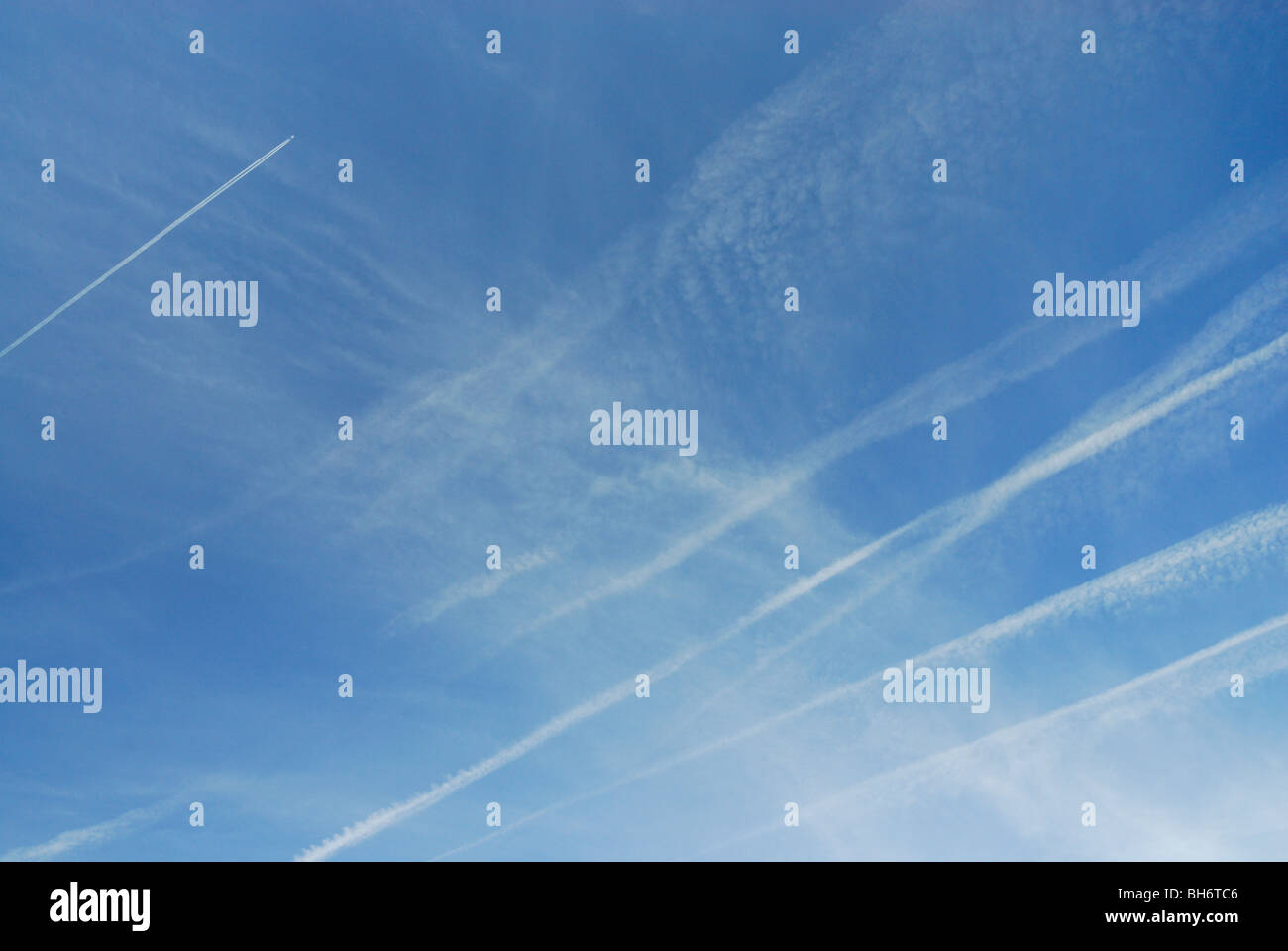 High altitude jet aircraft contrails filling the sky on a typical ...