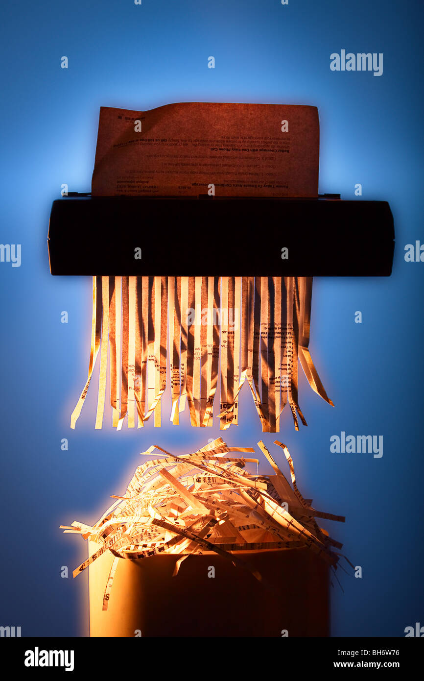 paper being shredded over a waste paper basket Stock Photo - Alamy
