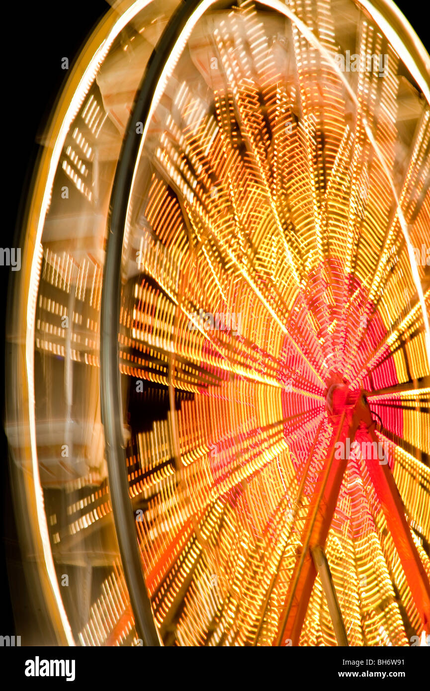 Swirling lights of carnival rides at night Stock Photo - Alamy