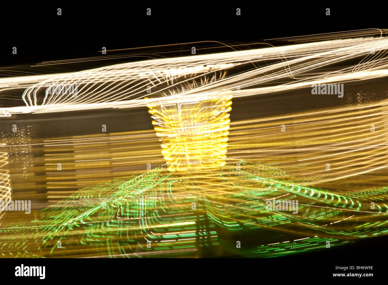 Swirling lights of carnival rides at night Stock Photo - Alamy