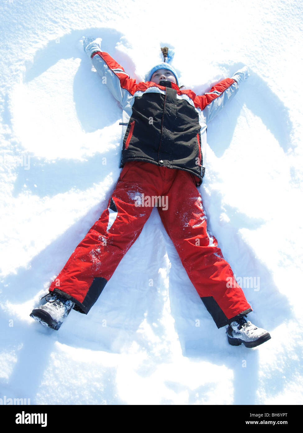 Girl making snow angel Stock Photo - Alamy