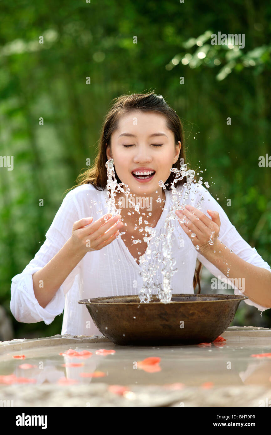 Young woman splashing water on her face Stock Photo - Alamy